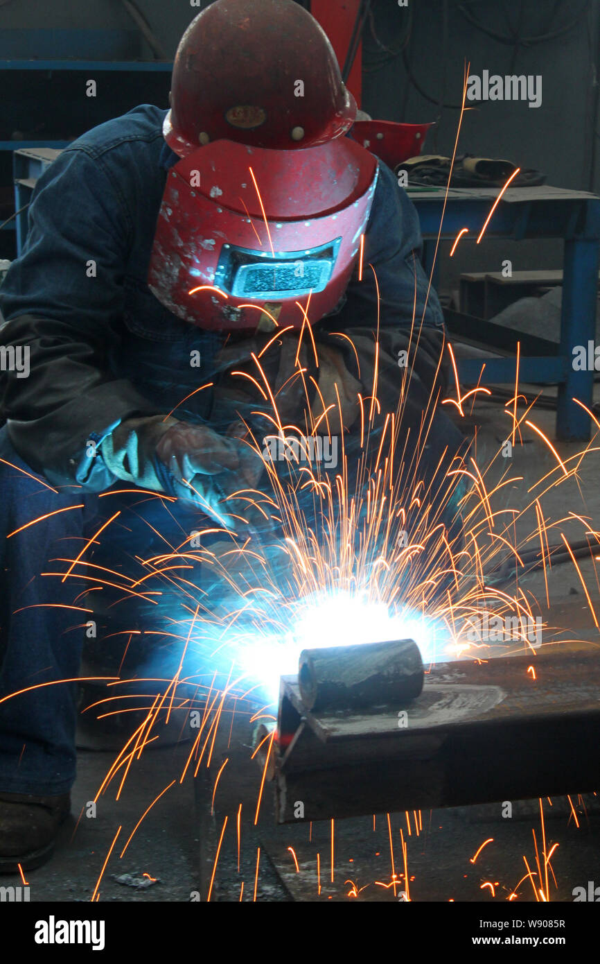 A Chinese worker welds a steel product at a factory in Jinan city, east ...