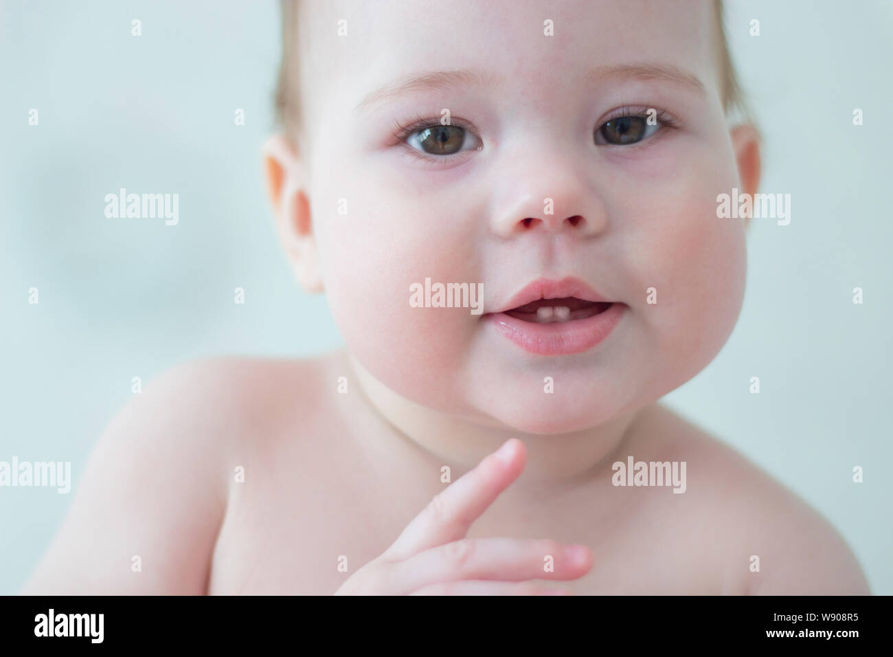 Little baby boy girl child 7-8 months shows the first two teeth ...