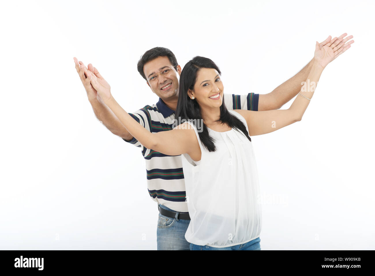 Couple standing with arm outstretched Stock Photo - Alamy