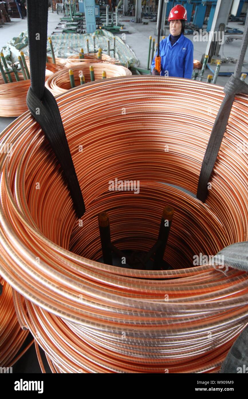 --FILE--A Chinese worker handles production of coiled copper tubes at a ...