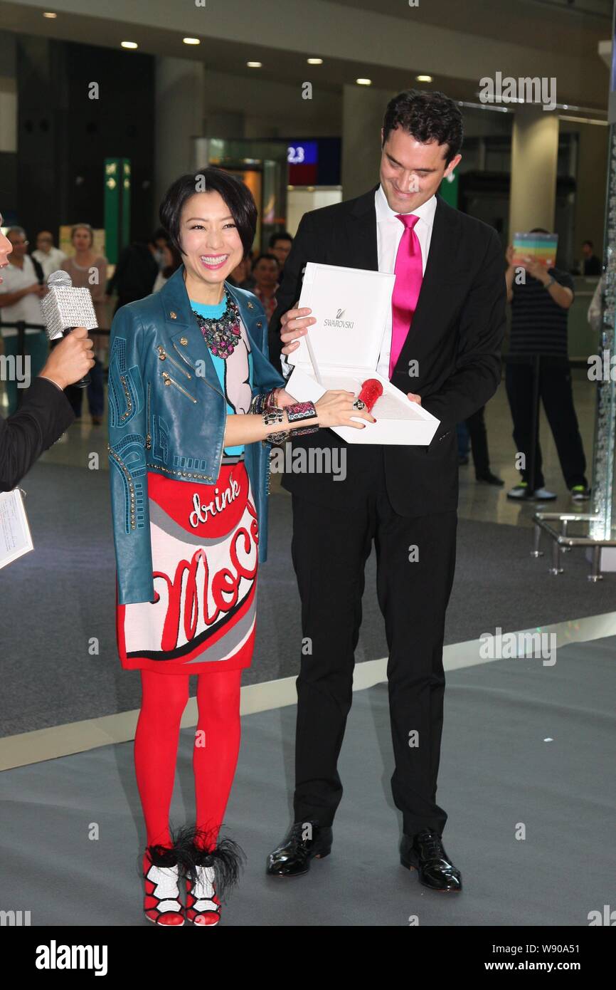 Hong Kong singer and actress Sammi Cheng, left, poses with an executive ...