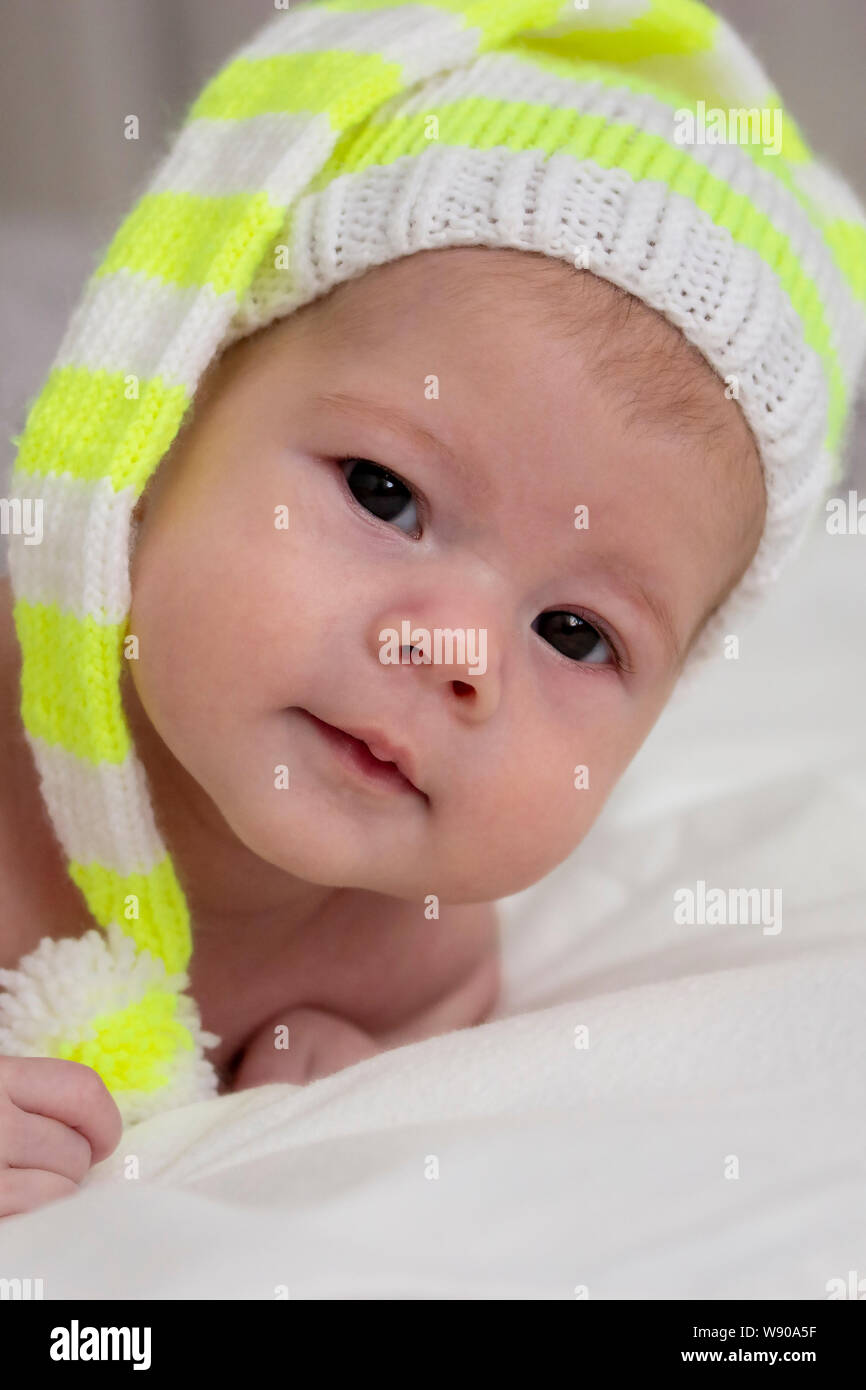 Portrait of baby 2 months child with a striped cap, close-up portrait ...