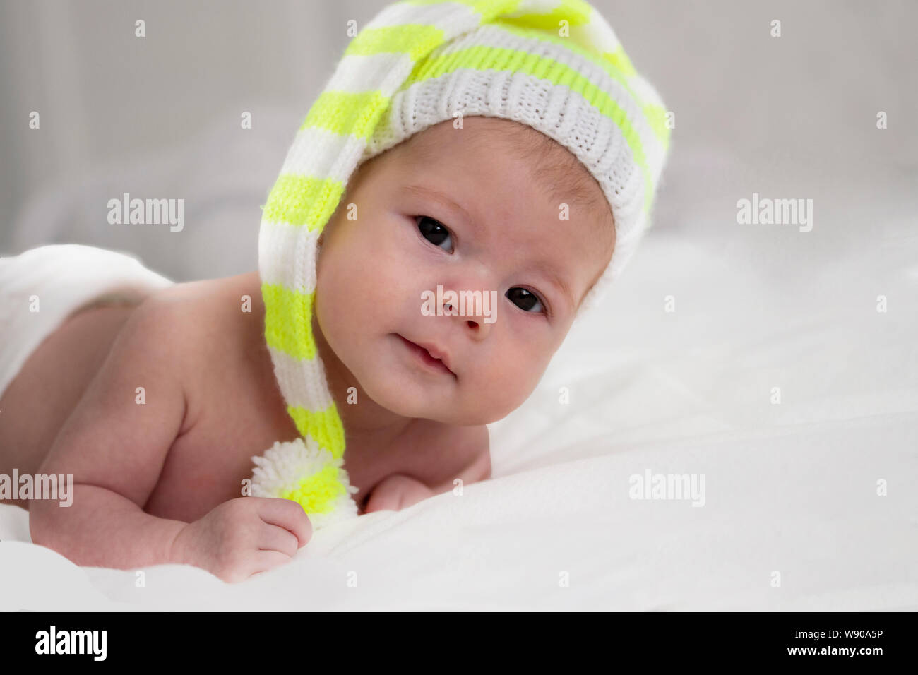 Portrait of baby 2 months old child with a striped cap, close-up ...