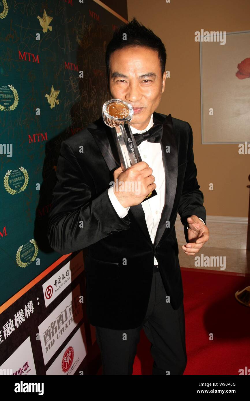 Hong Kong actor Simon Yam kisses his trophy during the 6th Macau ...