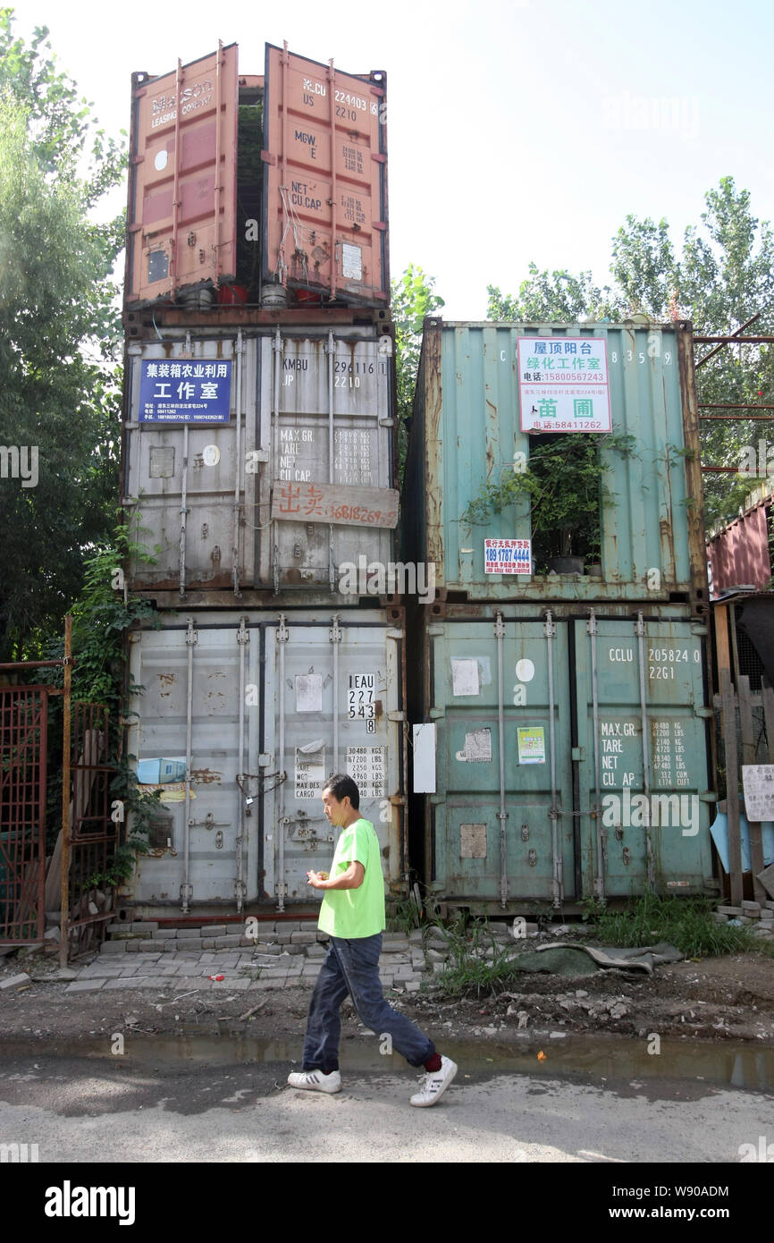 A pedestrian walks past a cluster of shipping-container homes in Pudong ...