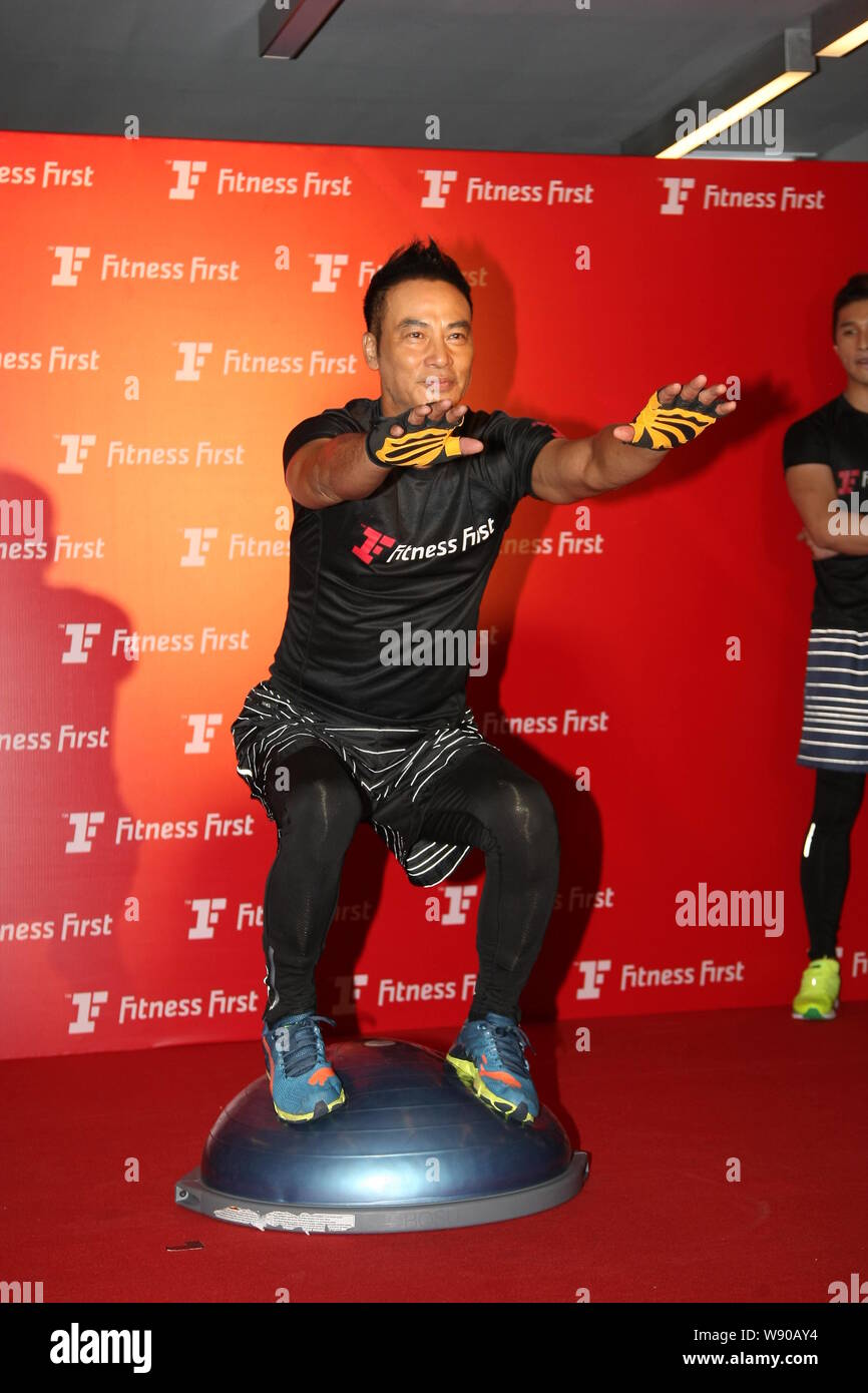 Hong Kong actor Simon Yam squats during the opening event for a fitness ...