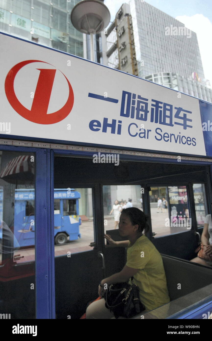 --FILE--Tourists sit in a sightseeing bus with an advertisement for ...
