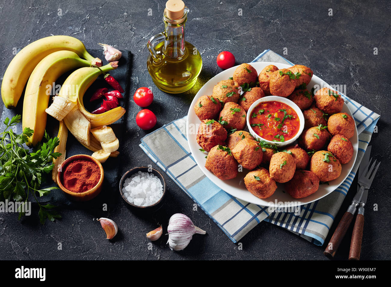 deep fried Plantain fritters Klako on a white plate with hot sauce ...