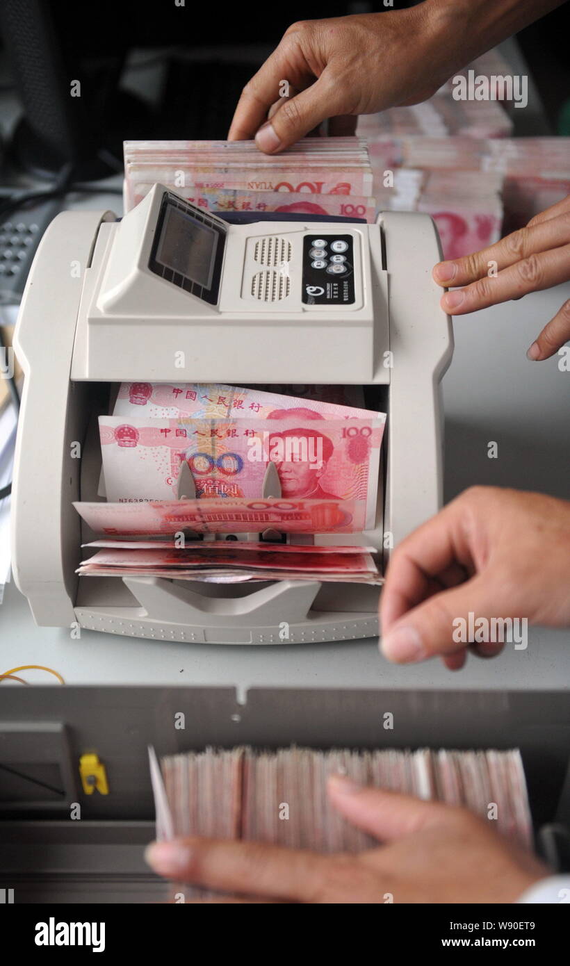 --FILE--A Chinese clerk uses a cash-counting machine to count RMB ...