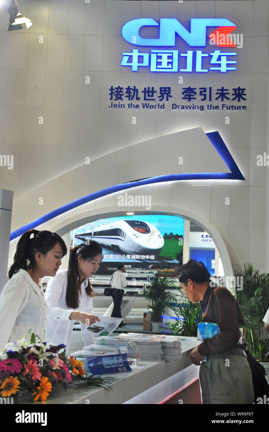 --FILE--A Chinese employee talks to a visitor at the stand of CNR ...