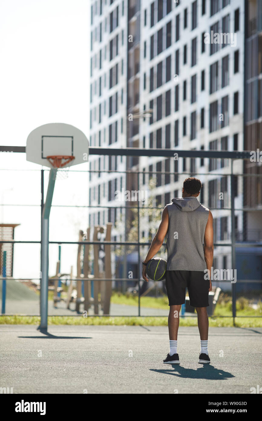 Back view portrait of African basketball player standing by hoop in ...