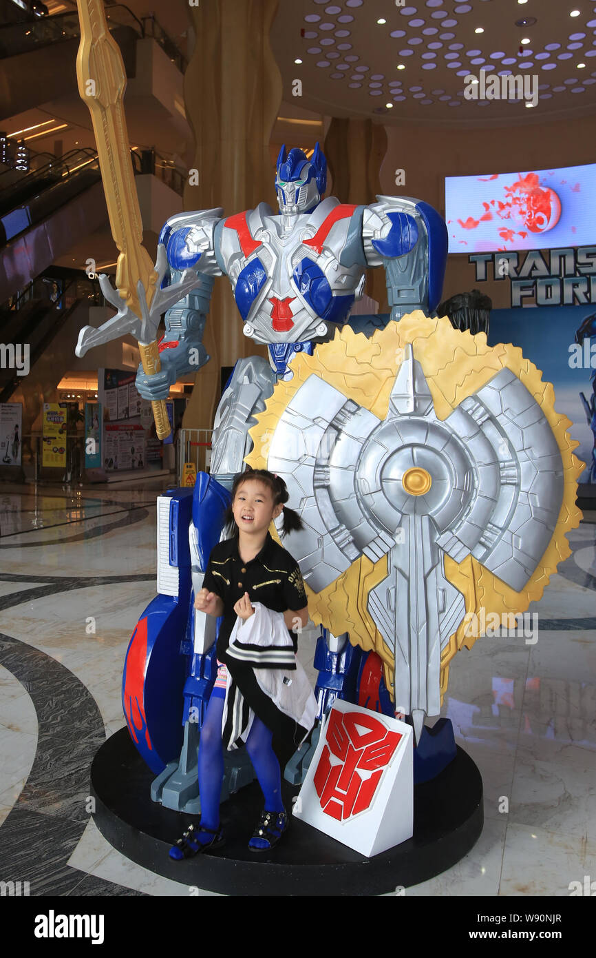A boy poses with a Transformer model during an exhibiton at the Joy ...