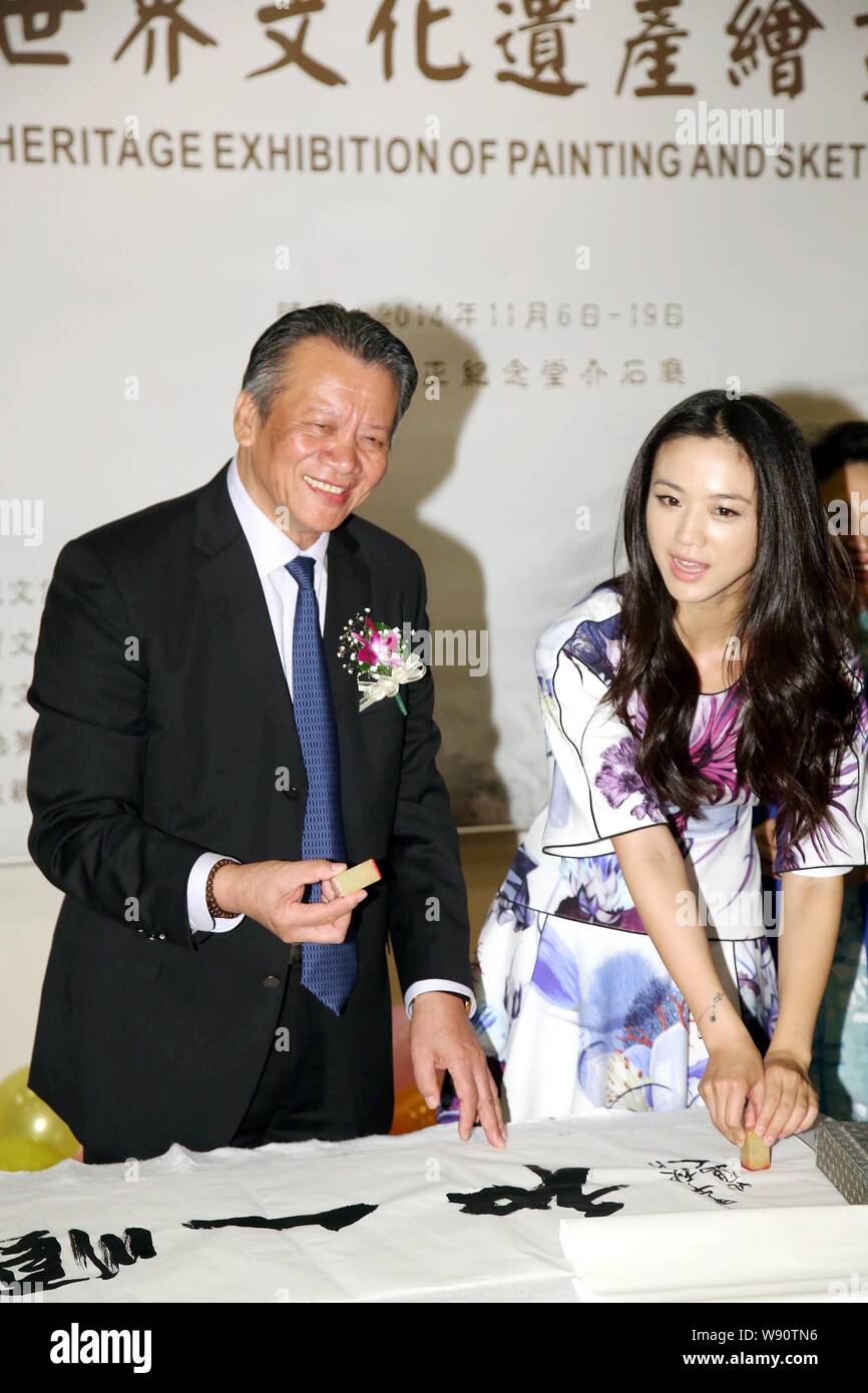 Chinese actress Tang Wei, right, seals a calligraphy work by his father ...