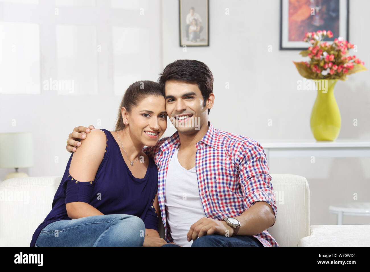 Young couple sitting together and smiling Stock Photo - Alamy