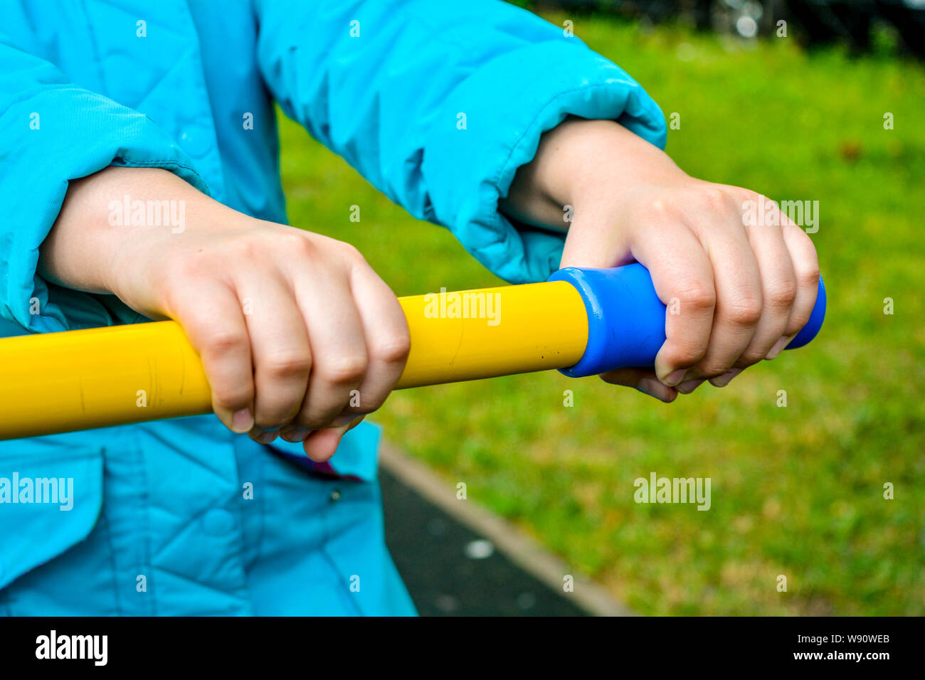Close up of child hands holding handle of children's sports equipment ...