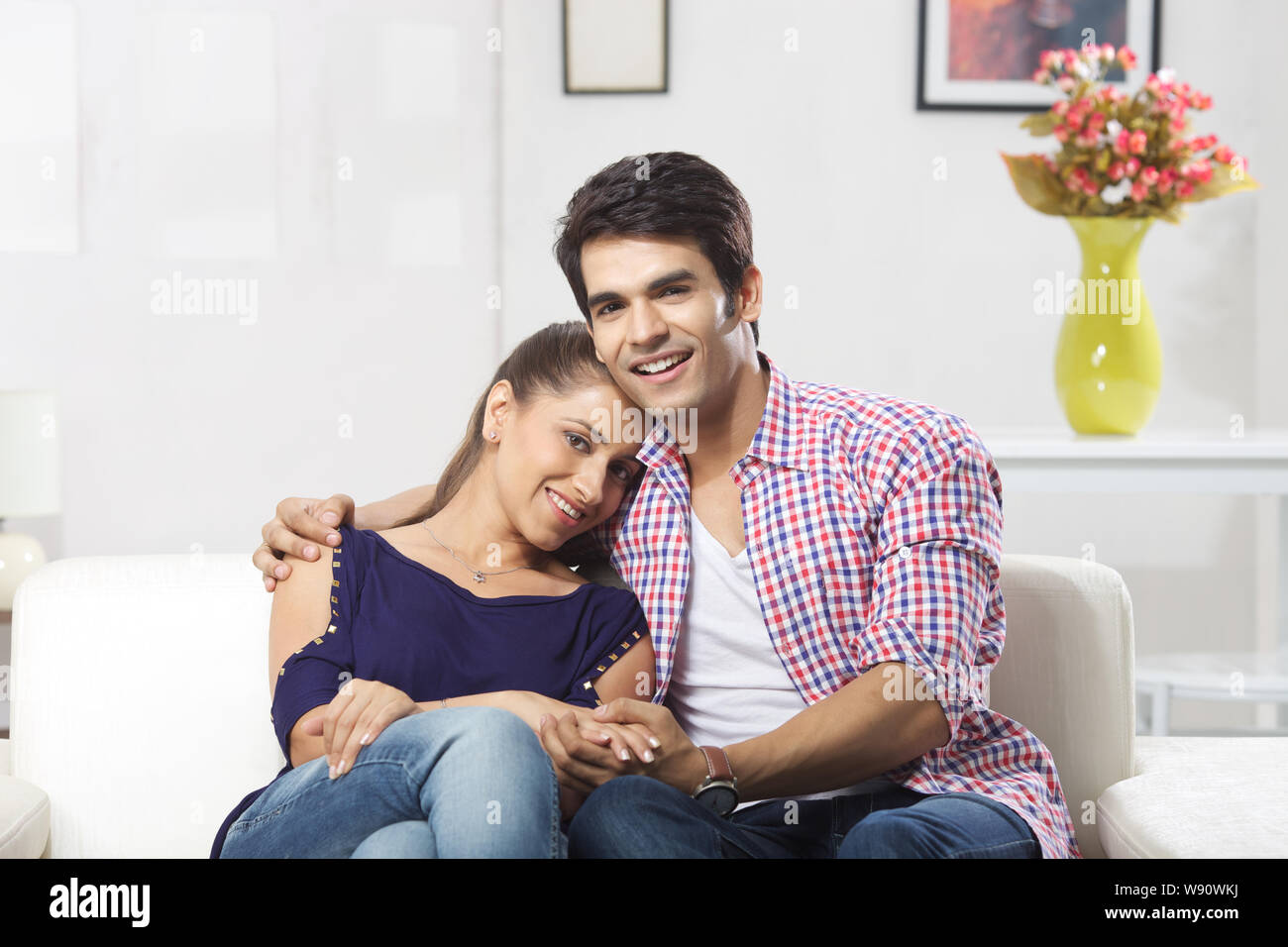 Young couple sitting together and smiling Stock Photo - Alamy