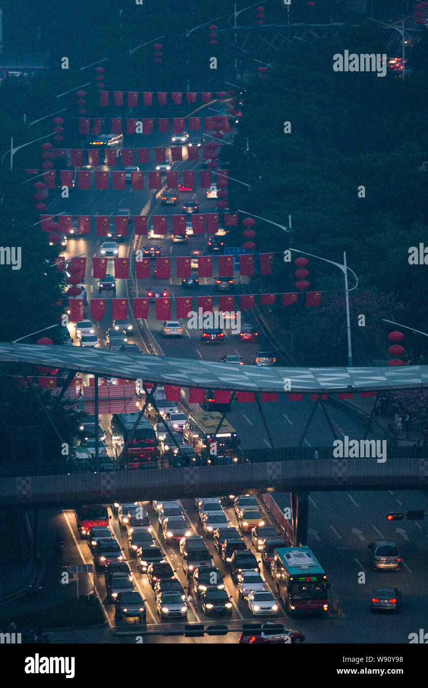 Masses of vehicles move slowly in a traffic jam on a road decorated ...