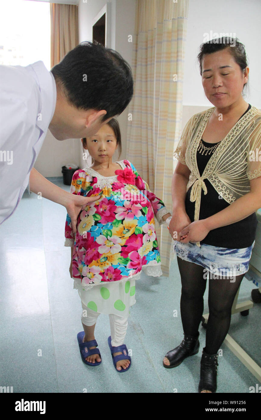A doctor examines 12-year-old girl Han Bingbing who suffers from a ...
