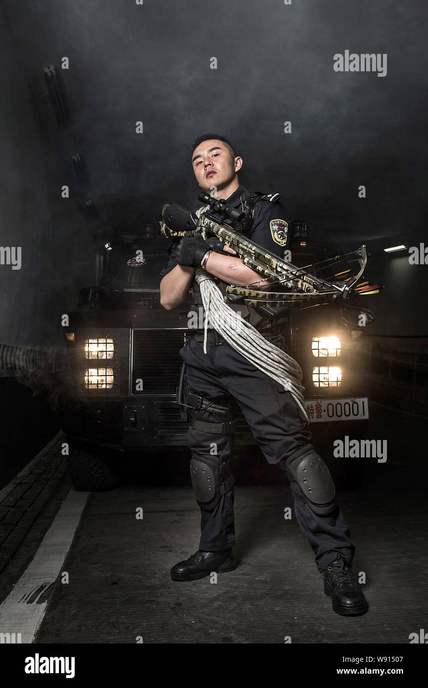 A SWAT police officer holding a crossbow poses for recruitment posters ...