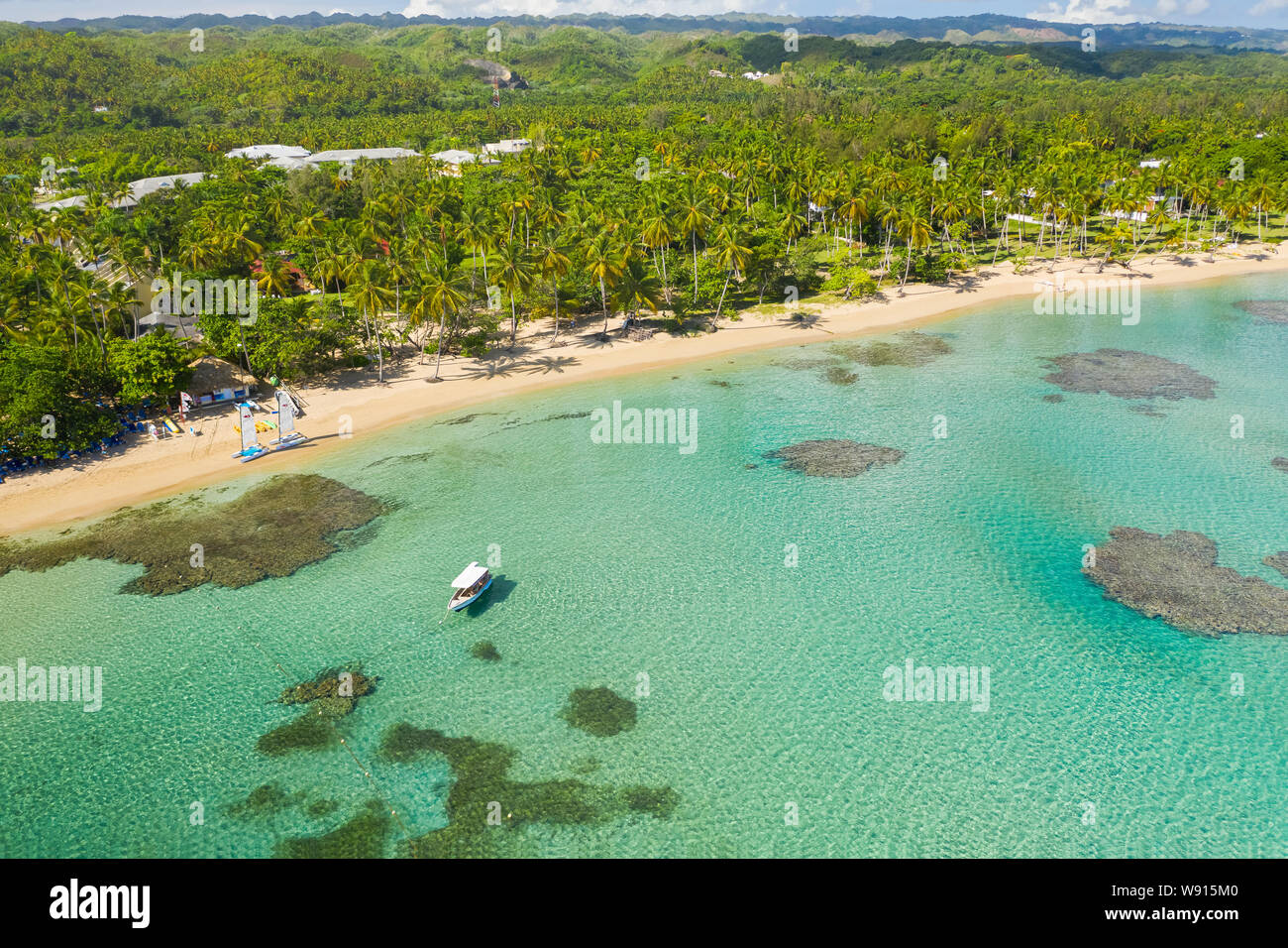 Drone shot of tropical beach with white boat anchored.Samana peninsula ...
