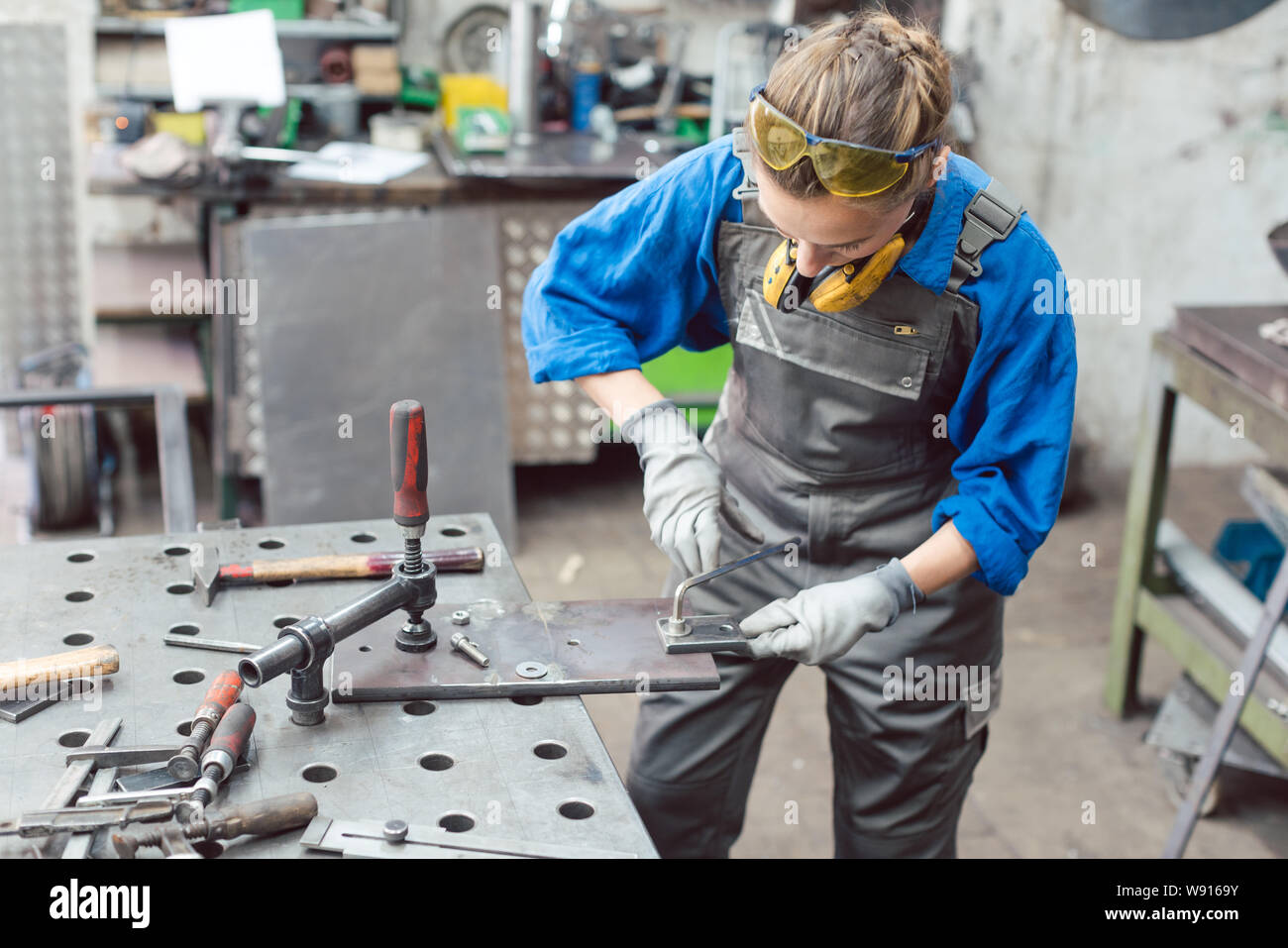 Woman mechanic working in metal workshop Stock Photo - Alamy