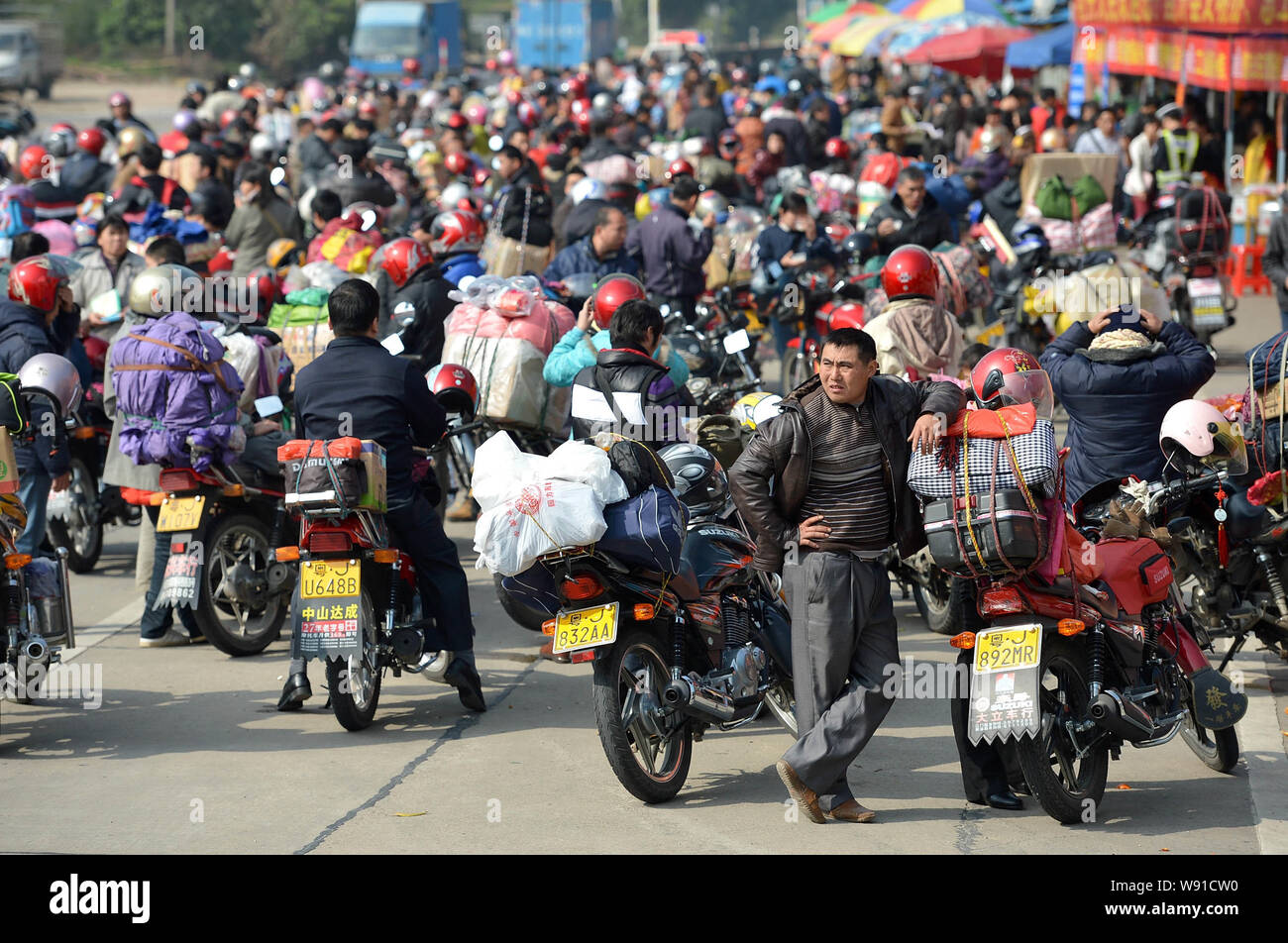 Chinese migrant workers on their way back by motorcycle for the Chinese ...