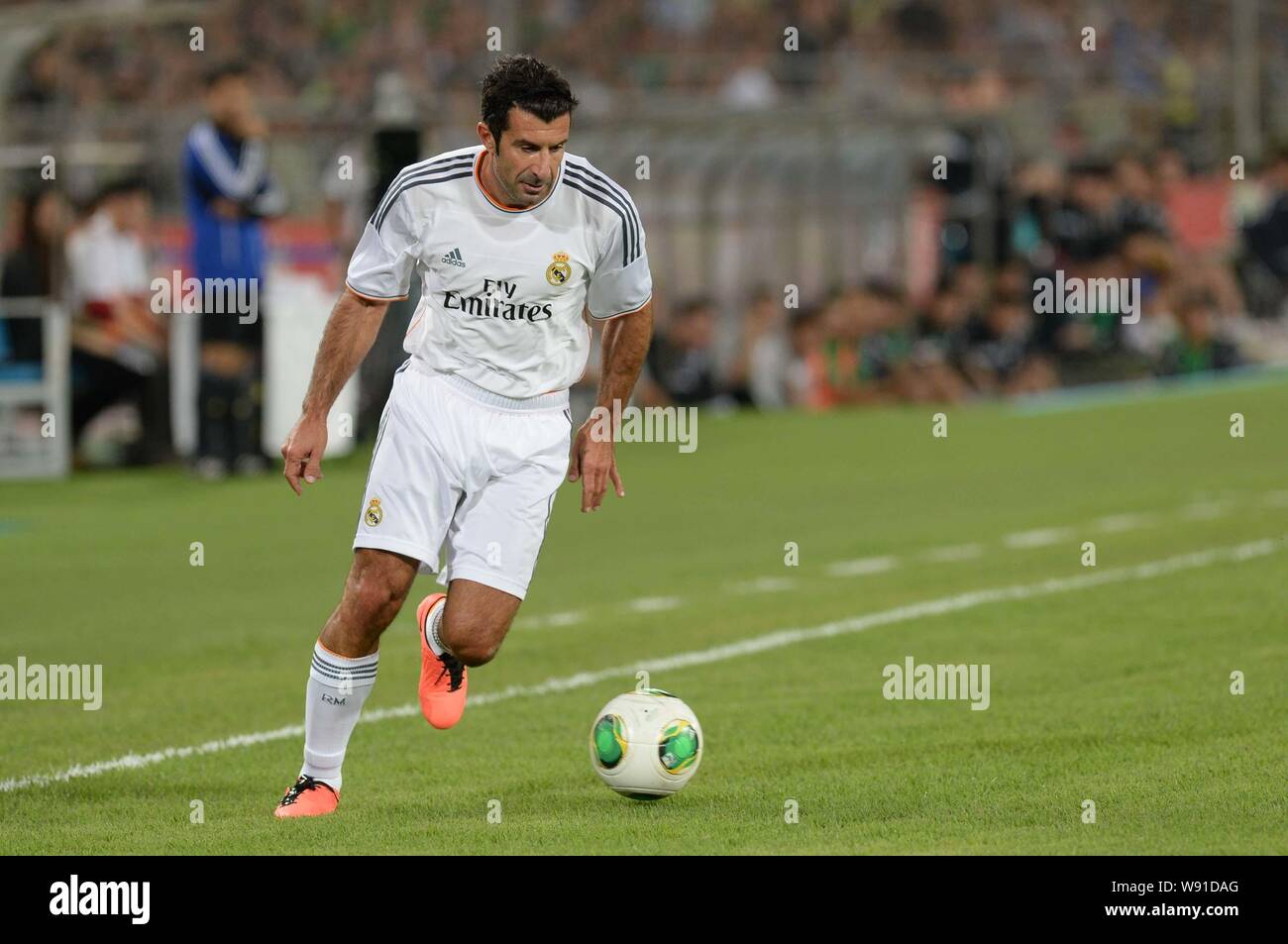 Portuguese football star Luis Figo of Real Madrid Leyendas dribbles in ...