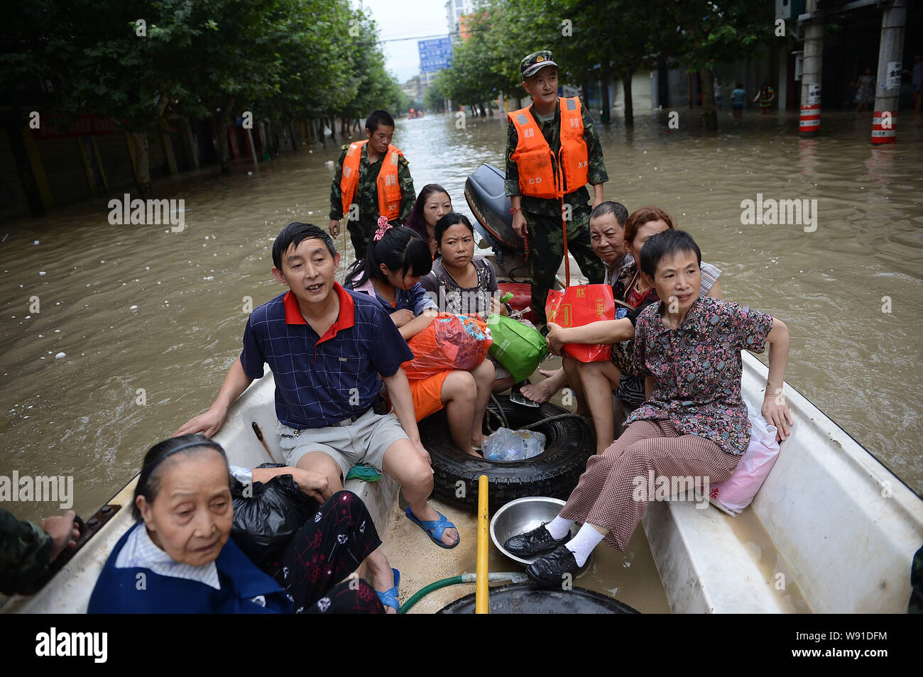 Local residents are evacuated by boat from flooded areas caused by ...