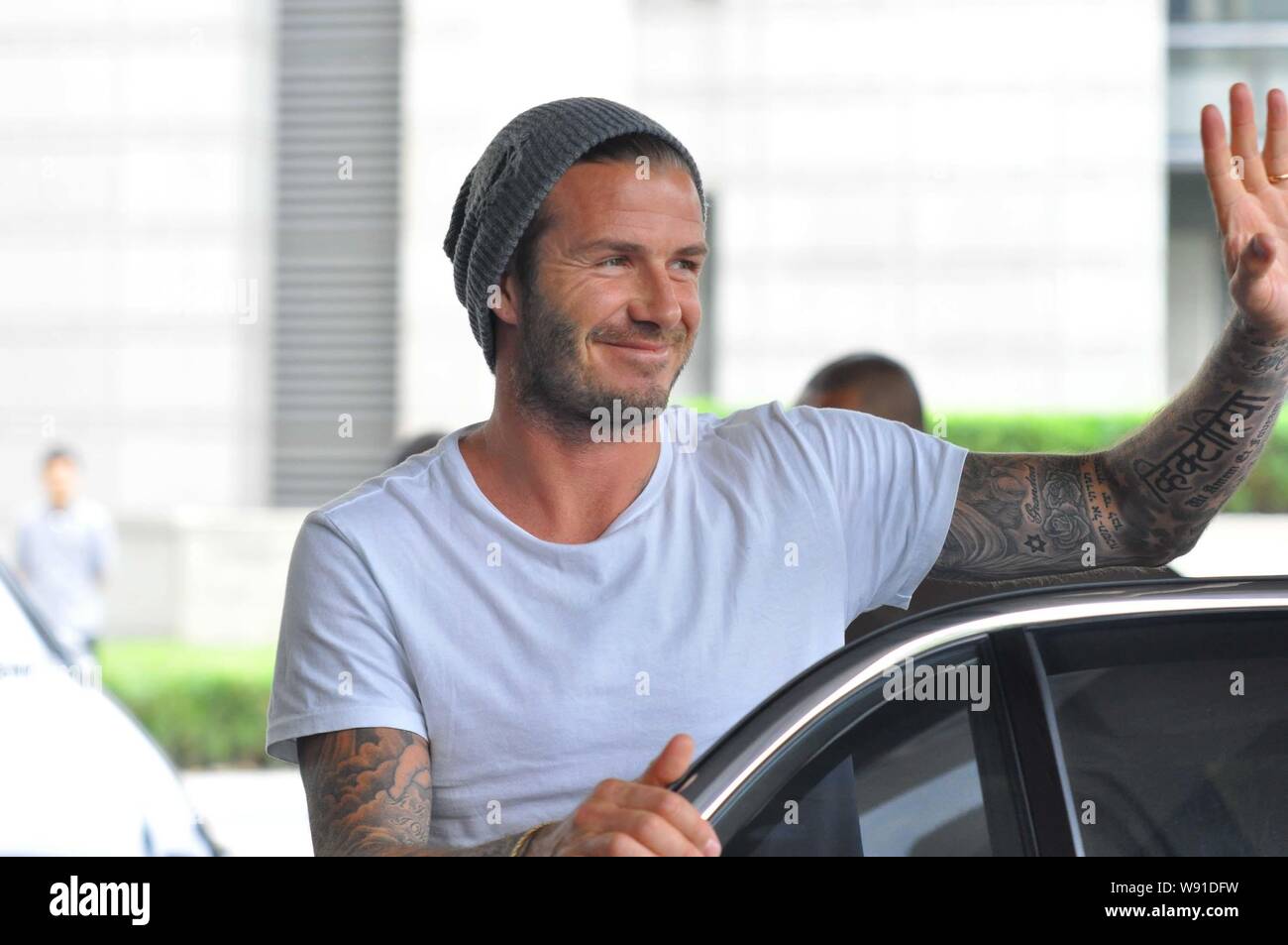 English football superstar David Beckham smiles and waves as he exits a ...