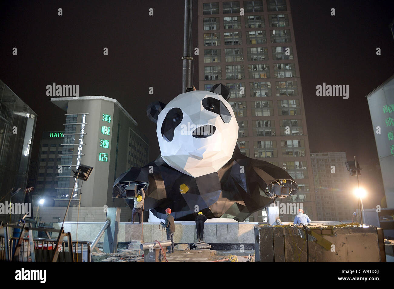 A giant panda-shaped art installation is being installed on the facade ...
