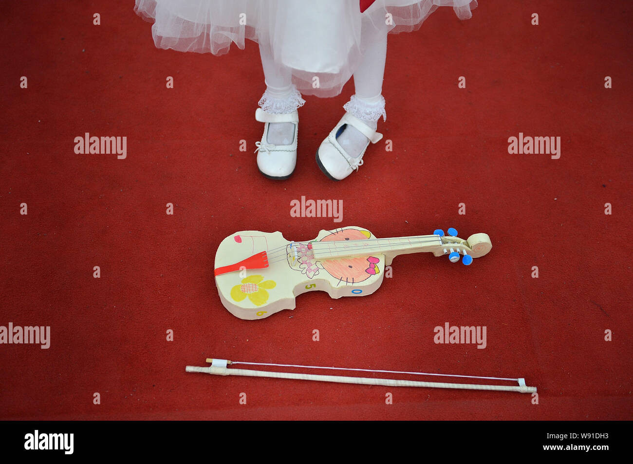 A female young student of the Paper Orchestra stands behind her paper ...