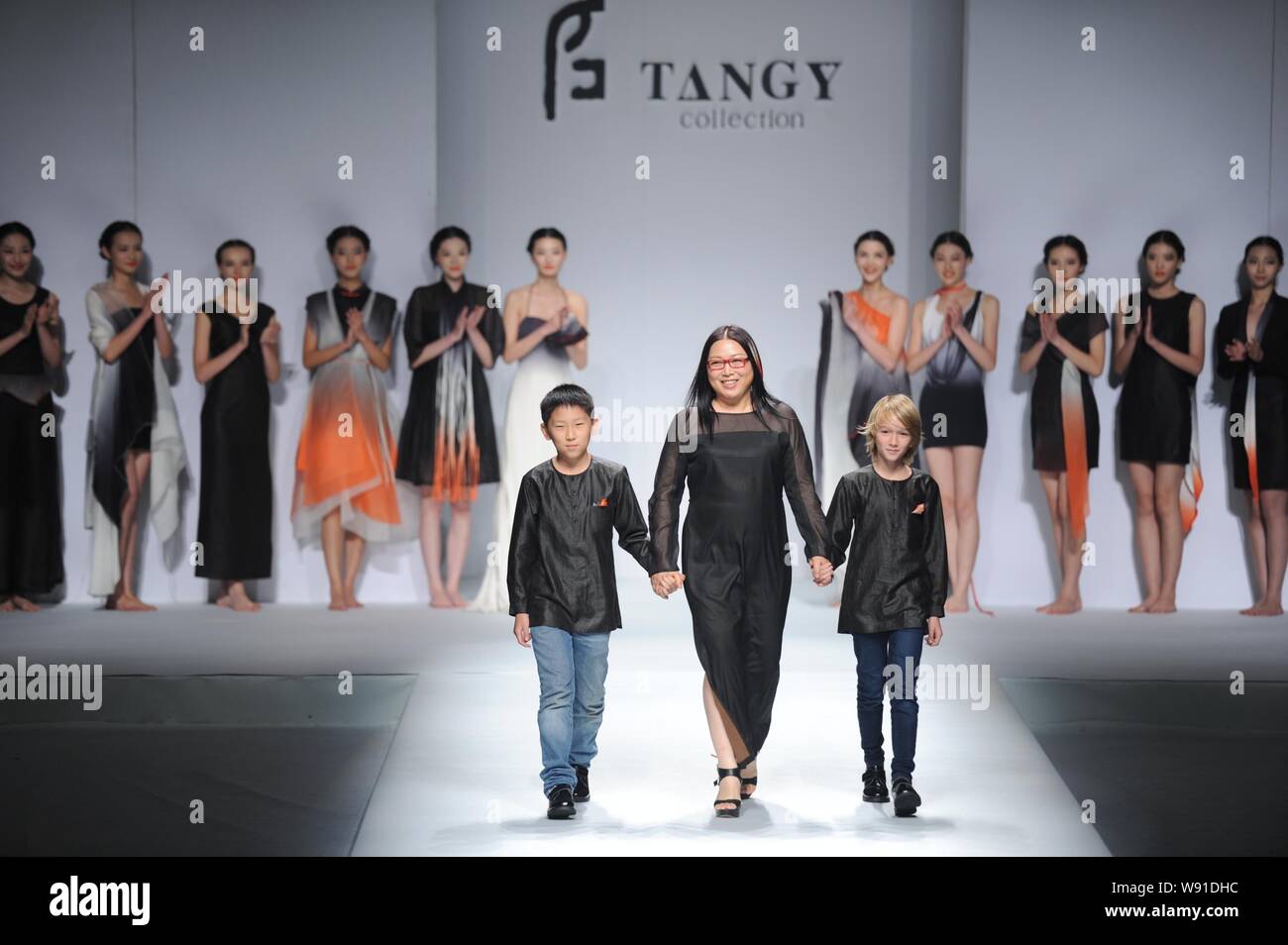 Fashion designer Liang Zi, front center, is pictured holding hands with ...