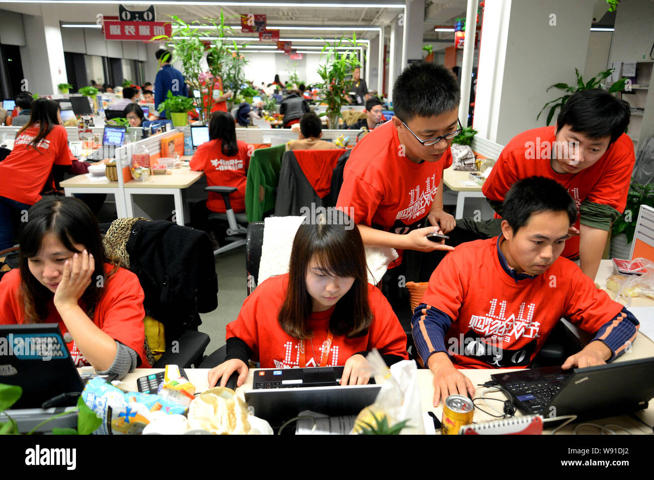 Chinese employees work at their desks at the headquarters of Chinese ...
