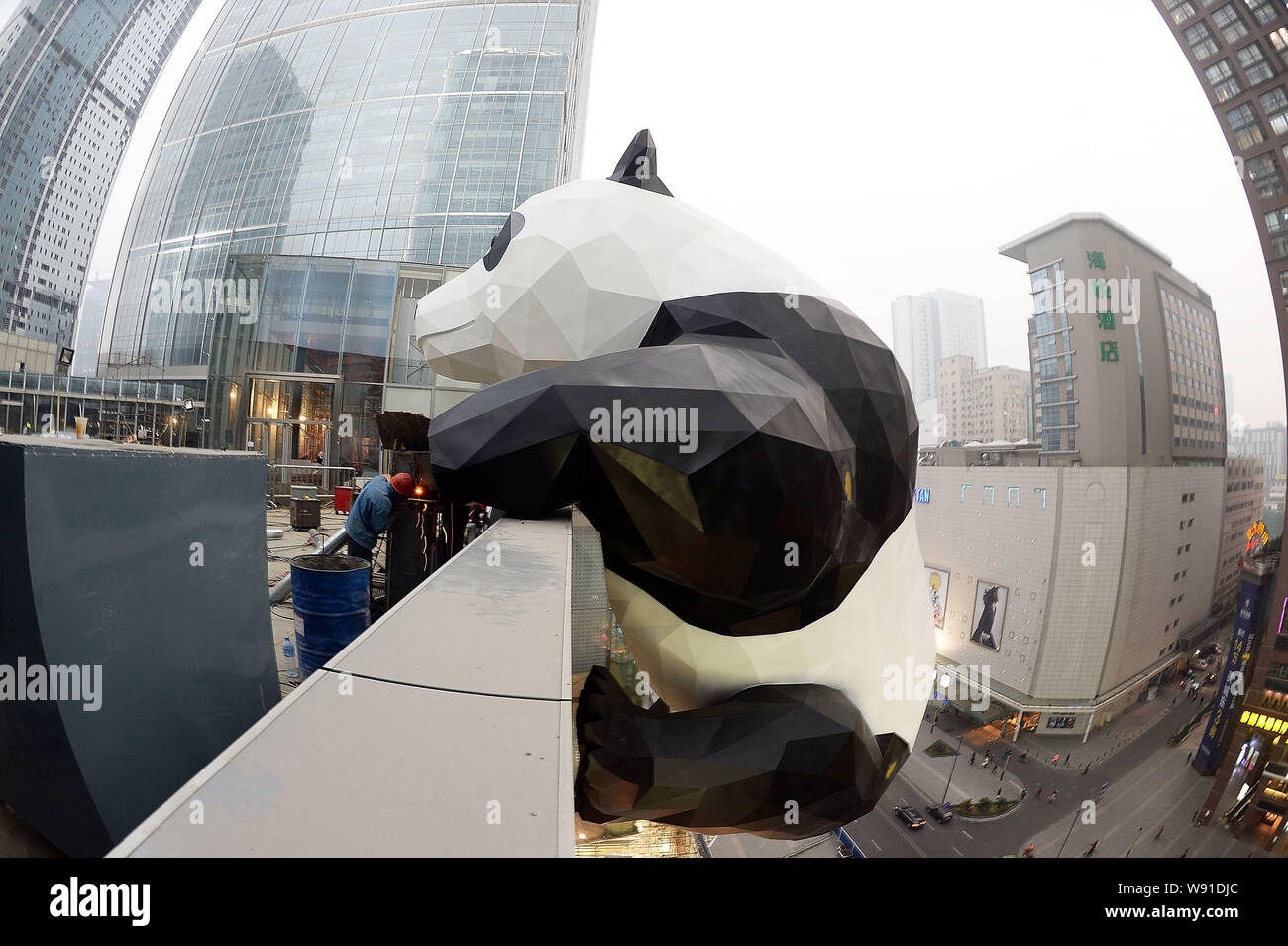 Chinese workers weld steel frames to install a giant panda-shaped art ...