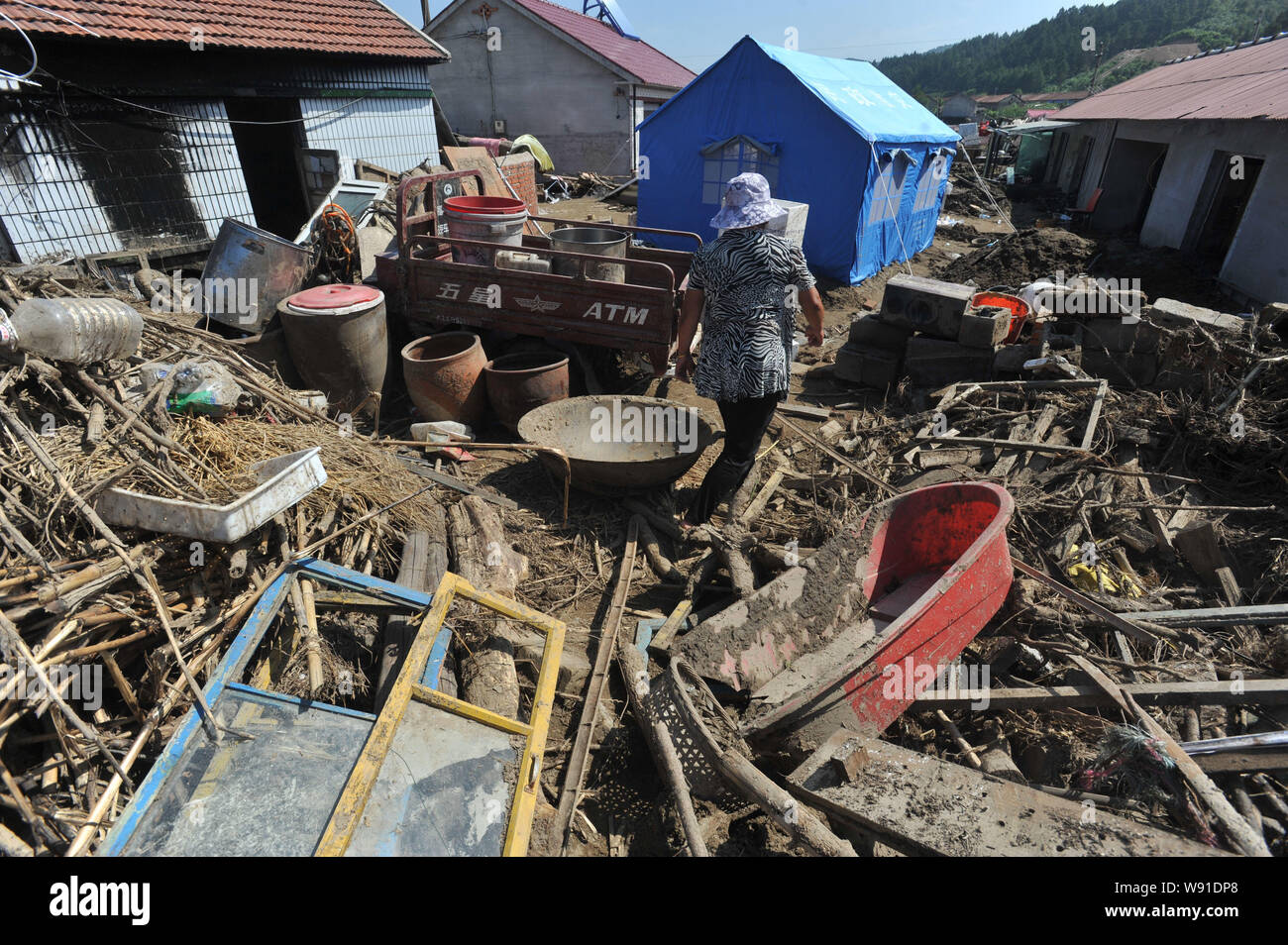 A local villager walks through the debris of the massive floods in ...