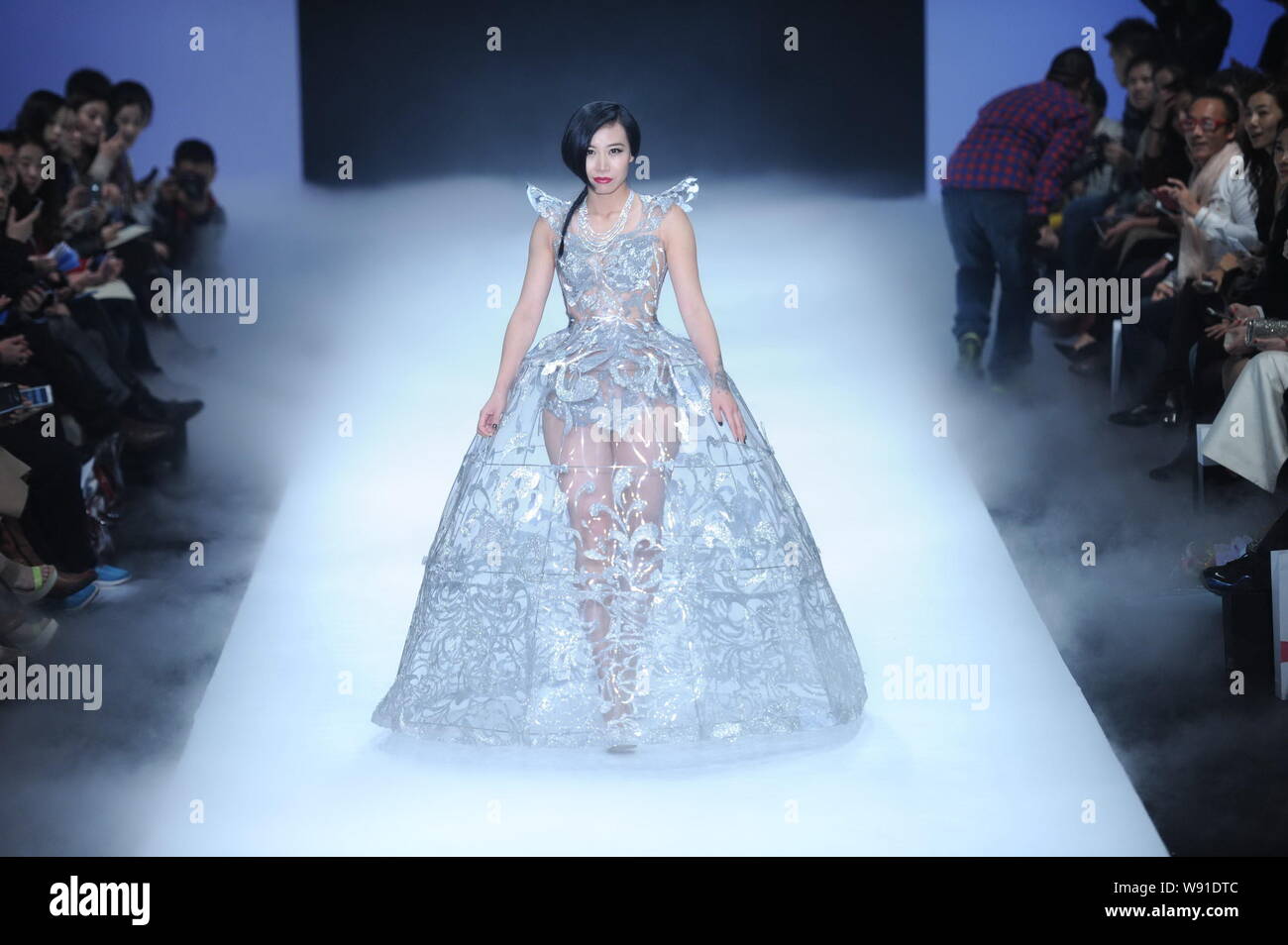 A model displays a new creation by designer Peng Jing at the All White ...