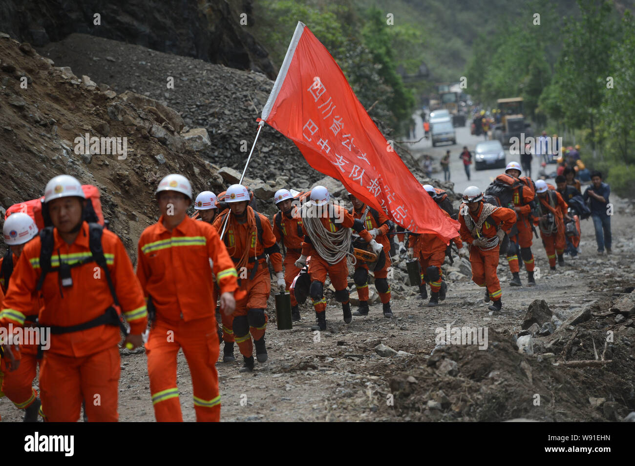 Chinese rescuers pass through the site of a landslide caused by the 7.0 ...