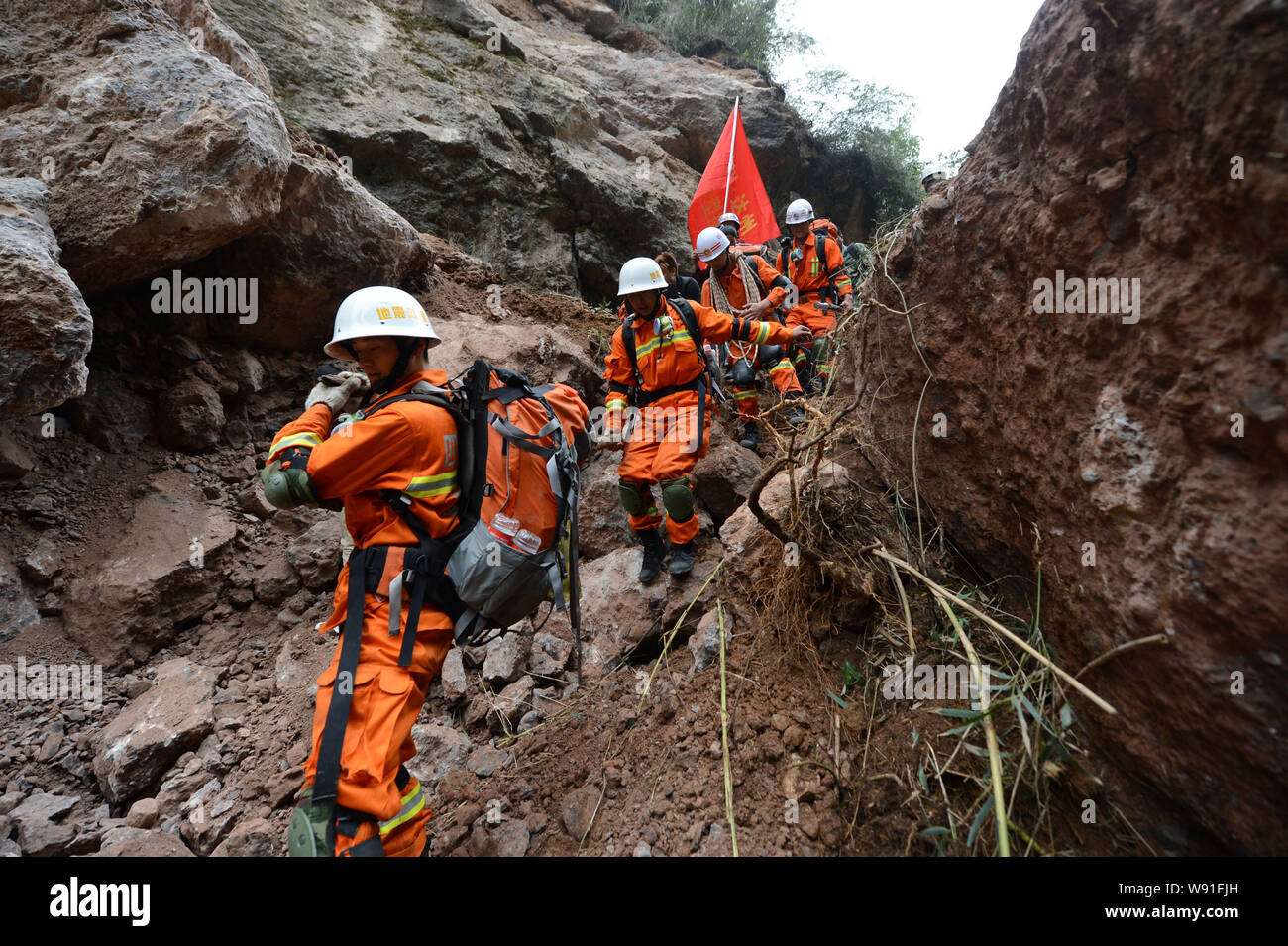 Chinese rescuers pass through the site of a landslide caused by the 7.0 ...