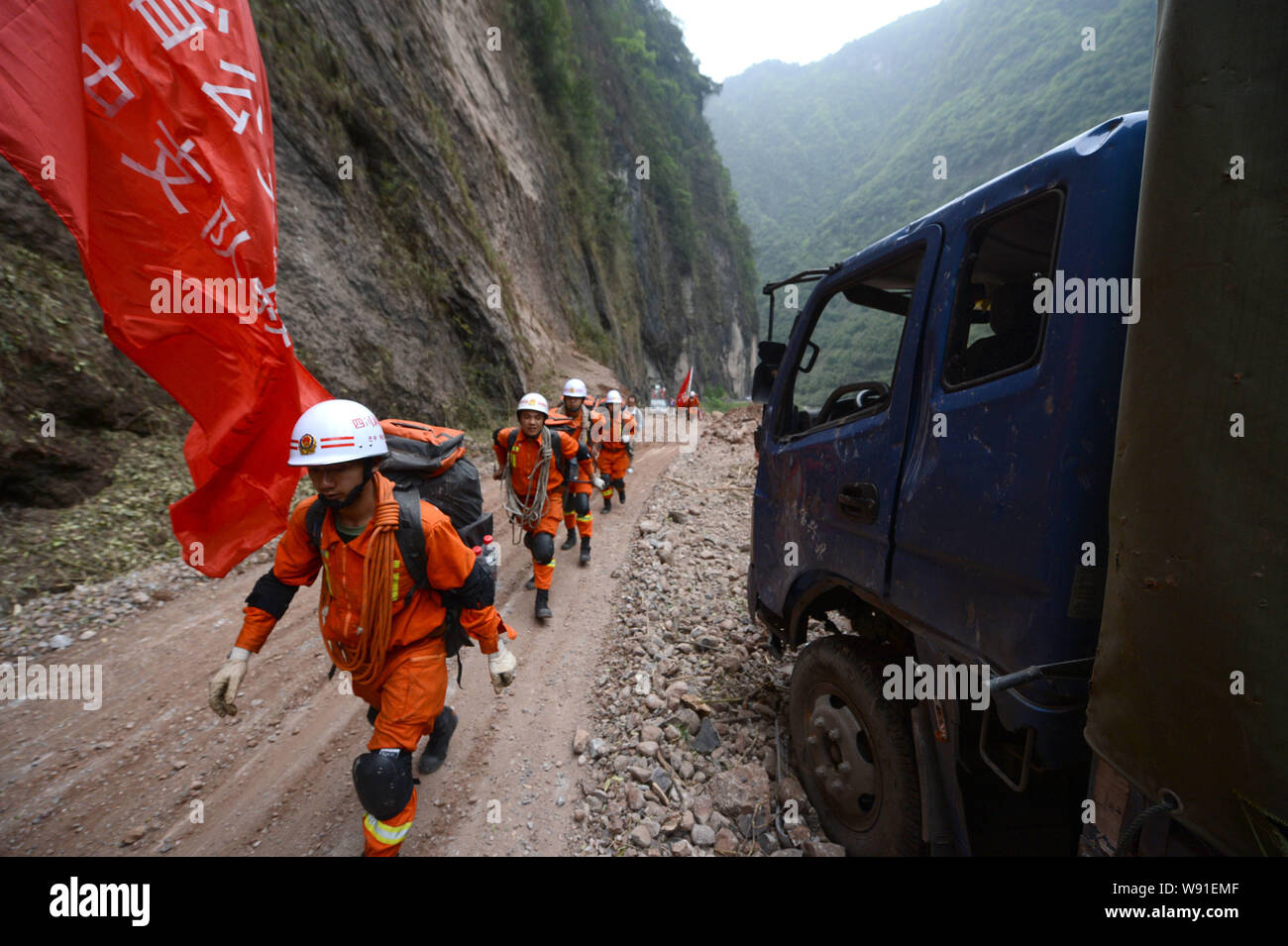 Chinese rescuers pass through the site of a landslide caused by the 7.0 ...