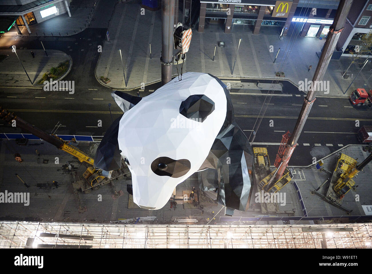 A giant panda-shaped art installation is being lifted before being ...