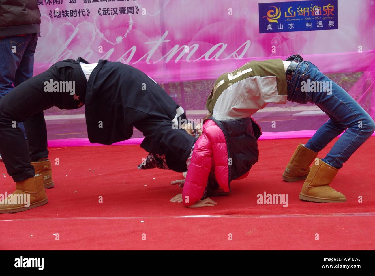 A young Chinese couple performs a kissing stunt at a kiss contest to ...