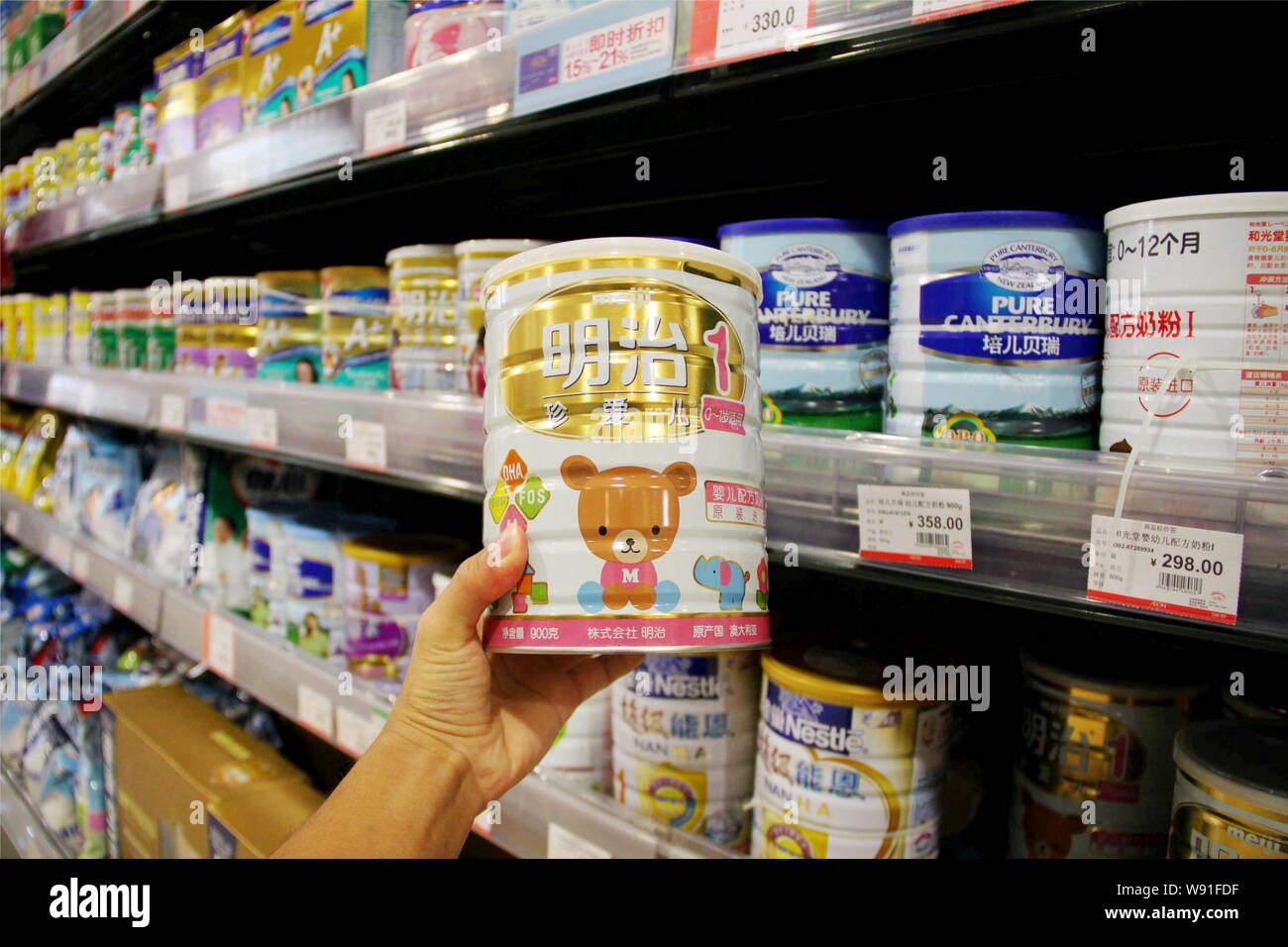A customer buys a tin of Meiji Cherish baby milk powder at a ...