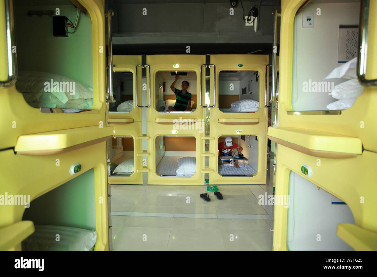 Customers rest in their cells at a capsule hotel in Haikou city, south ...