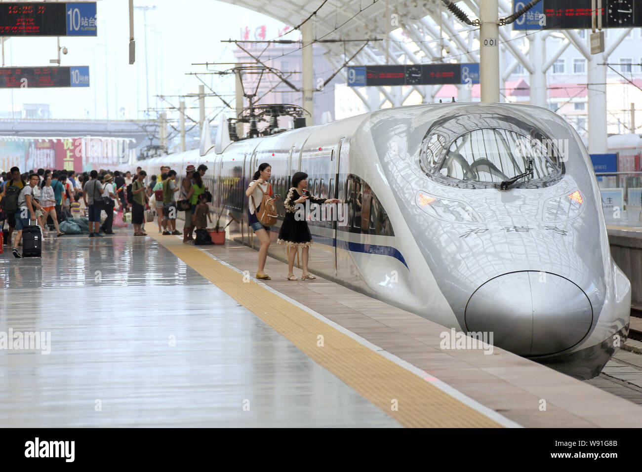 --FILE--Passengers board a CRH (China Railway High-speed) train at the Qingdao Railway Station ...