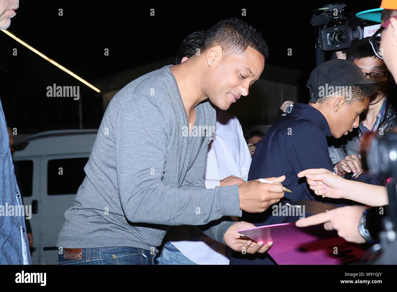 American actor Will Smith and his son Jaden Smith autograph for fans as ...