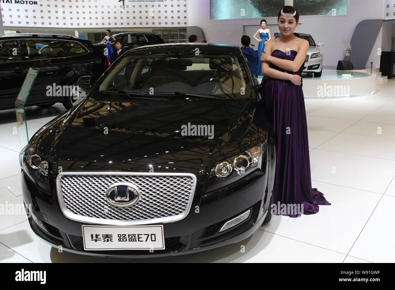 A model poses with a Lusheng E70 of Hawtai Motor during the 15th ...