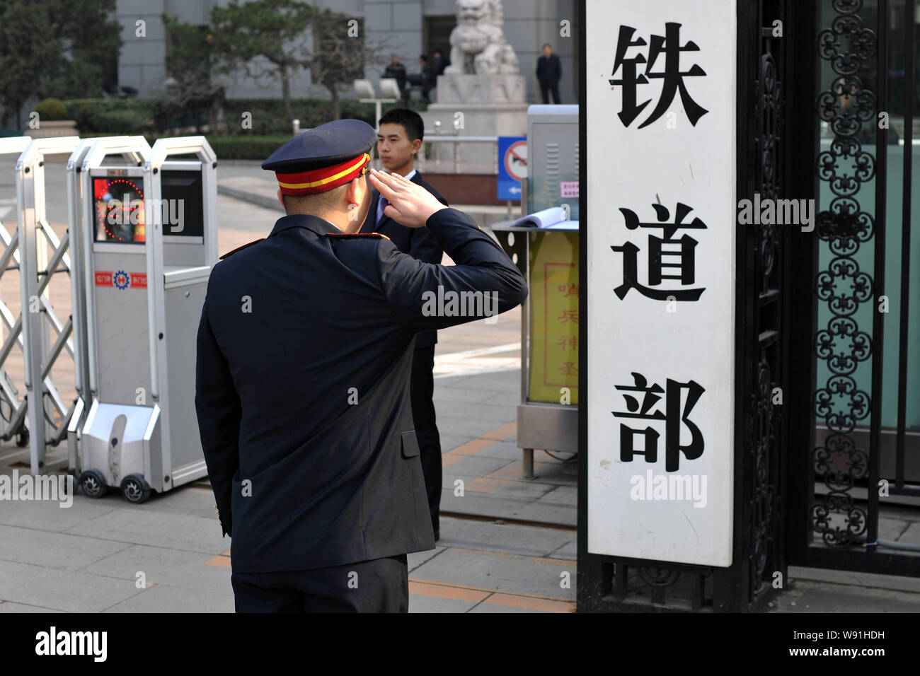 A Chinese railway worker salutes to the signboard at the gate of the ...