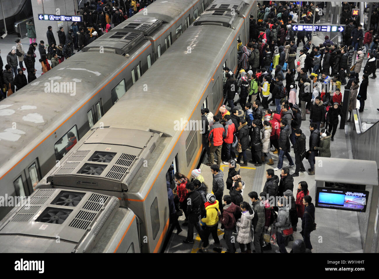 A crowd of passengers queue up to walk into a metro train at a subway ...