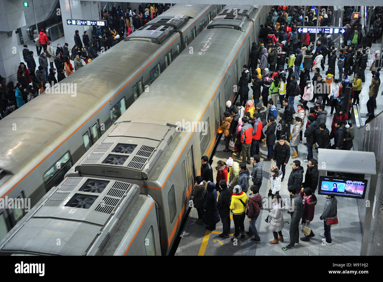 A crowd of passengers wait for metro trains at a subway station during ...
