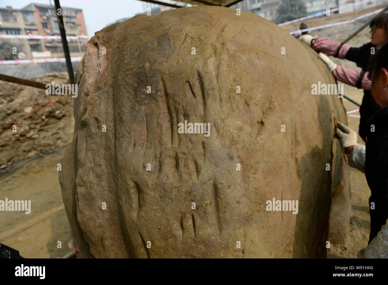 Chinese archaeologist clean a 2,000-year-old stone beast unearthed at ...
